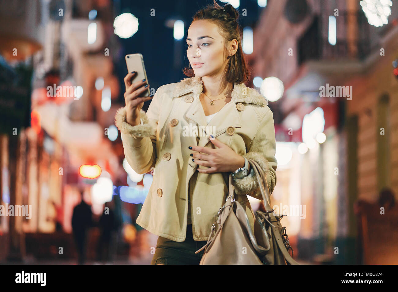 girl checking her phone outside at night Stock Photo - Alamy
