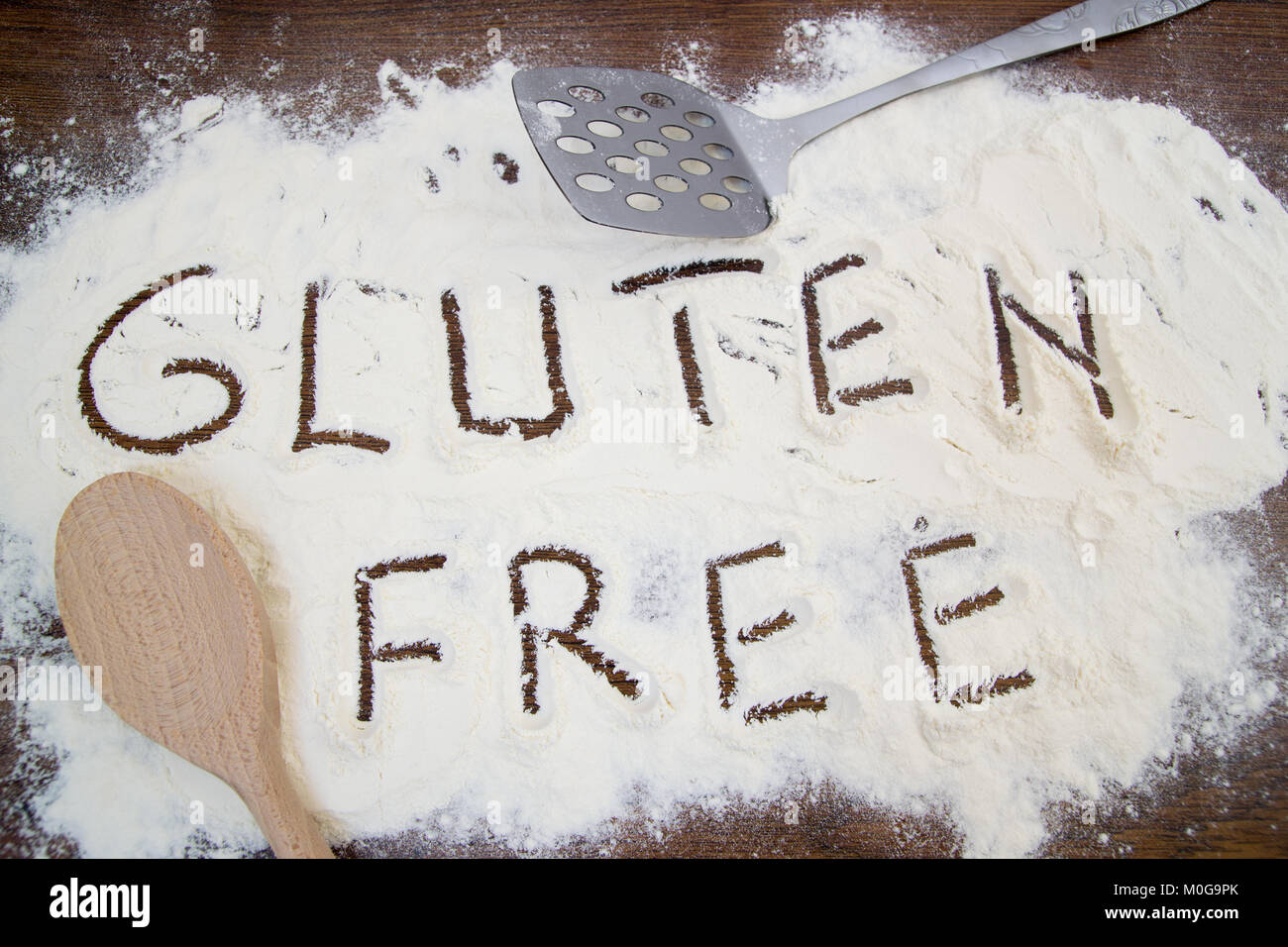Wheat flour and cooking tools on kitchen table. Gluten free text ...