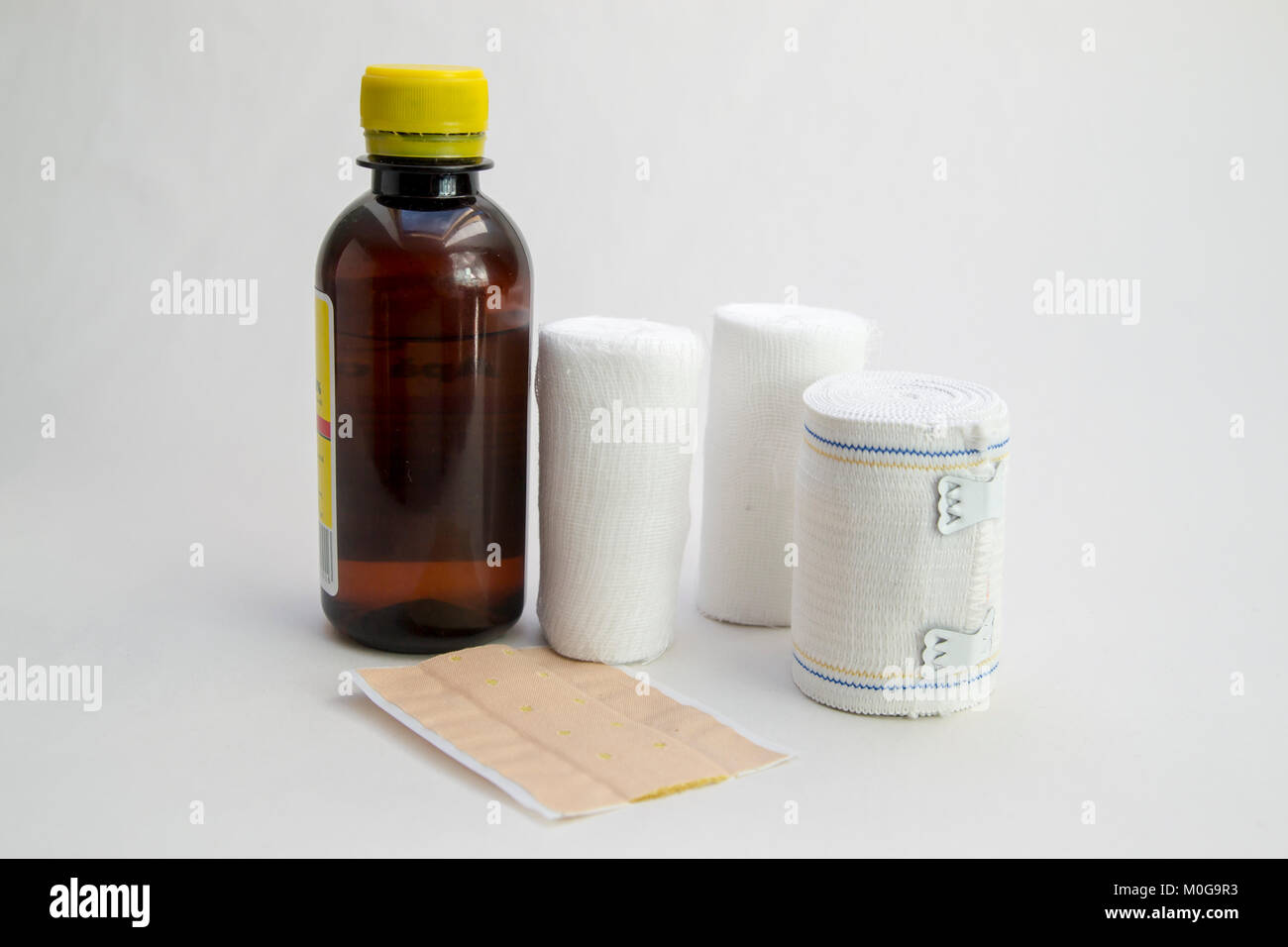 Bandages, patch and a bottle of disinfectant on white background. These ...