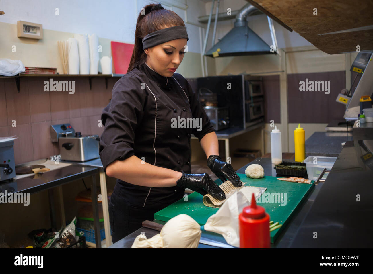 the Cook woman prepares food sushi restaurant kitchen Stock Photo - Alamy