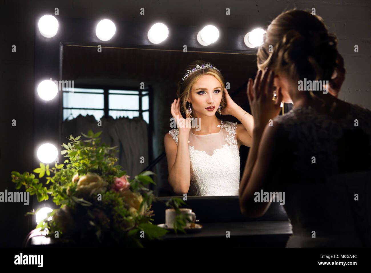Portrait of young bride near mirror back view. Brides morning Stock ...