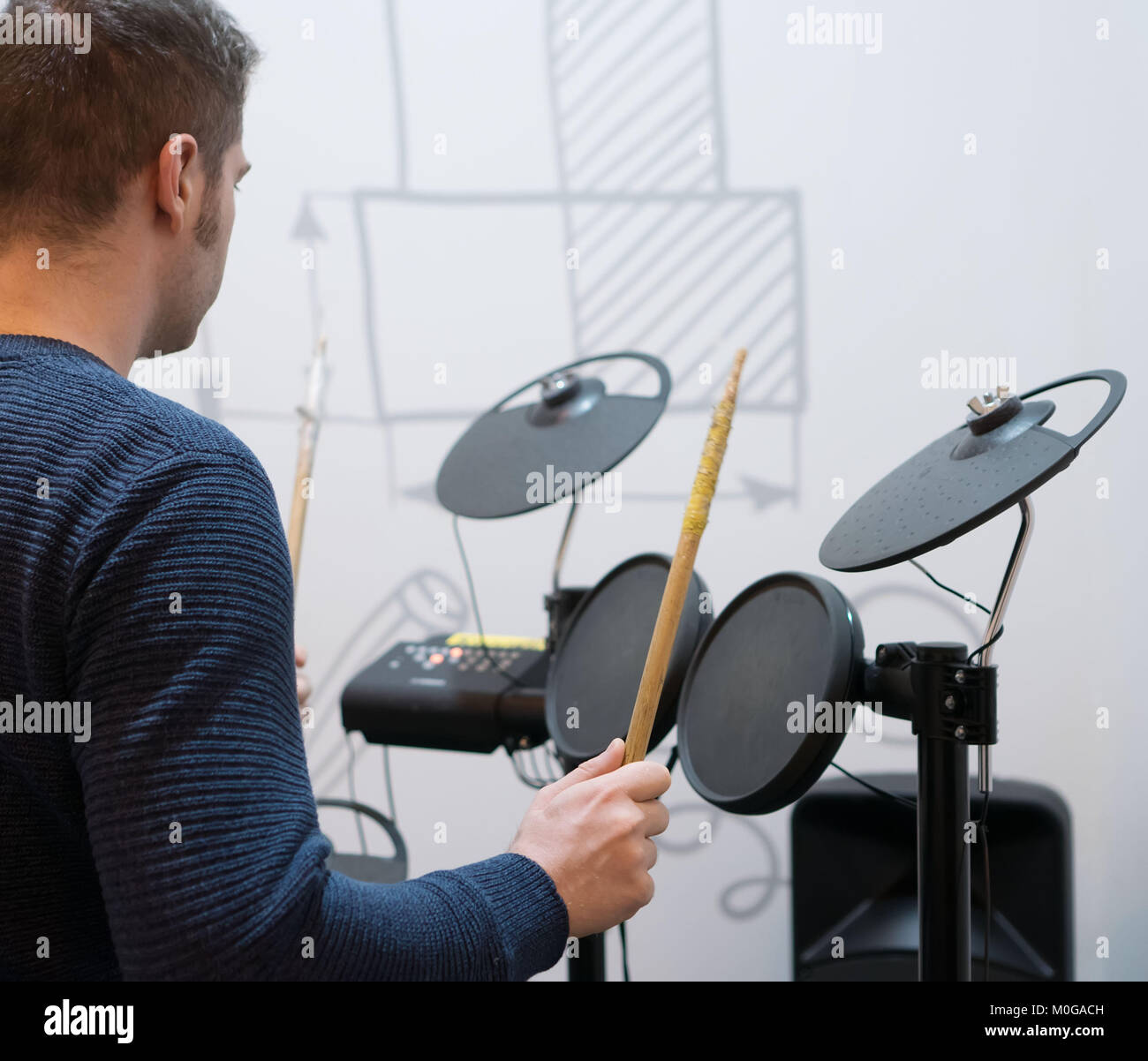 Man playing on electronic drums. Back view Stock Photo - Alamy