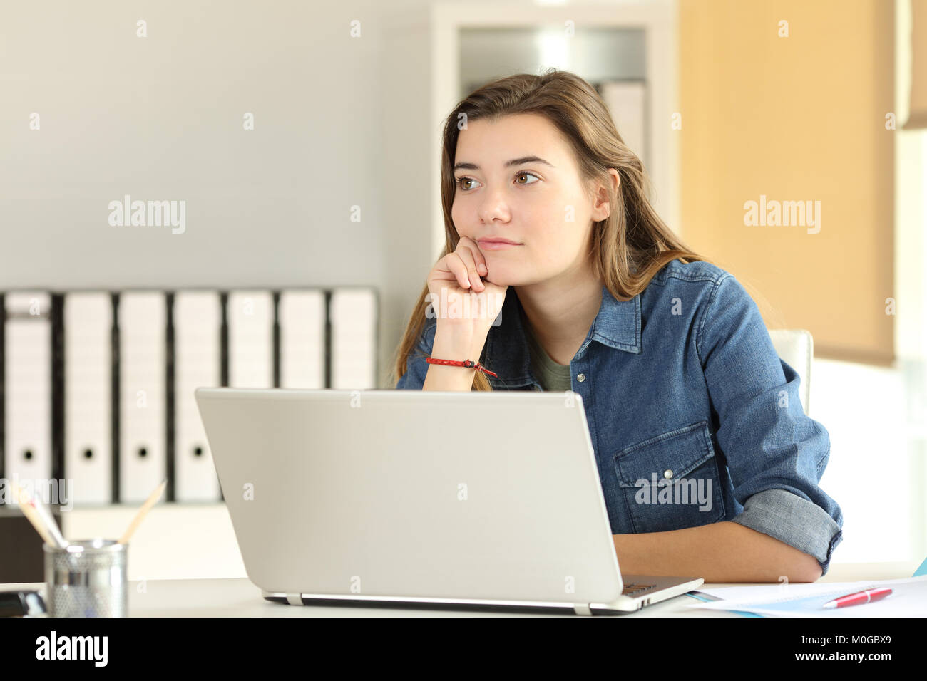 Pensive serious intern working at office Stock Photo - Alamy