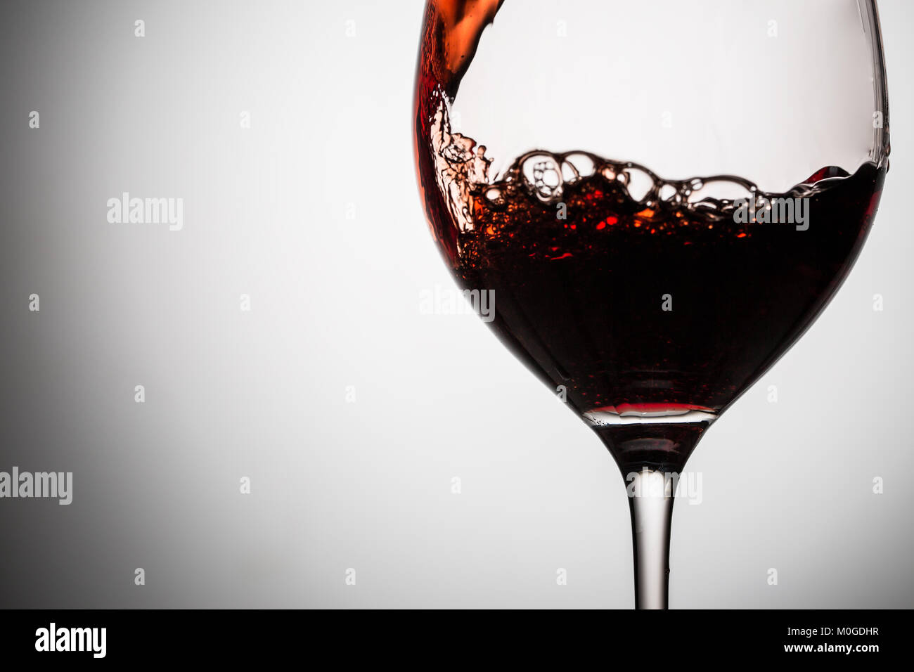 Red wine dripping down side of wineglass Stock Photo - Alamy