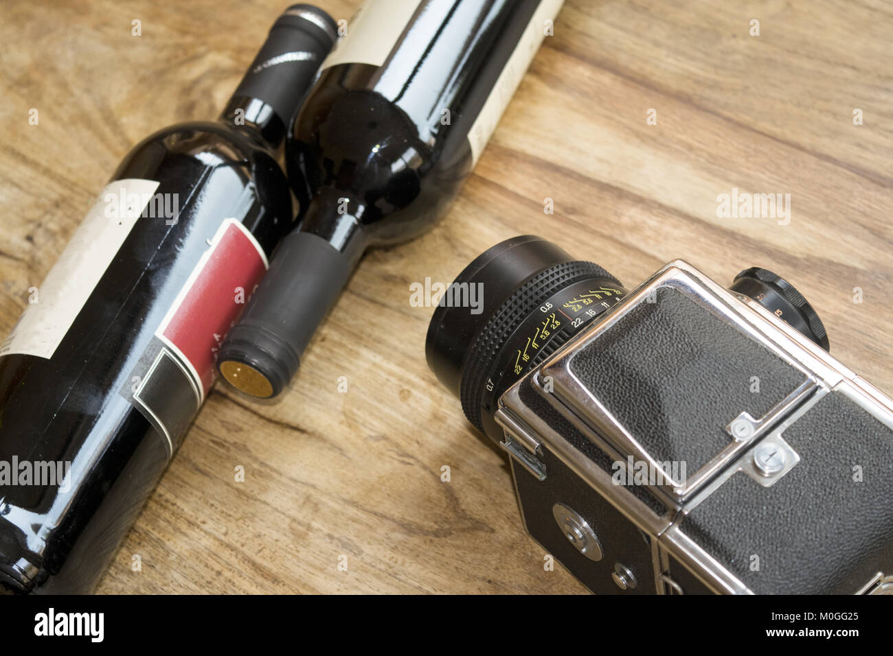 aged red wine bottles outstretched near an old camera Stock Photo - Alamy