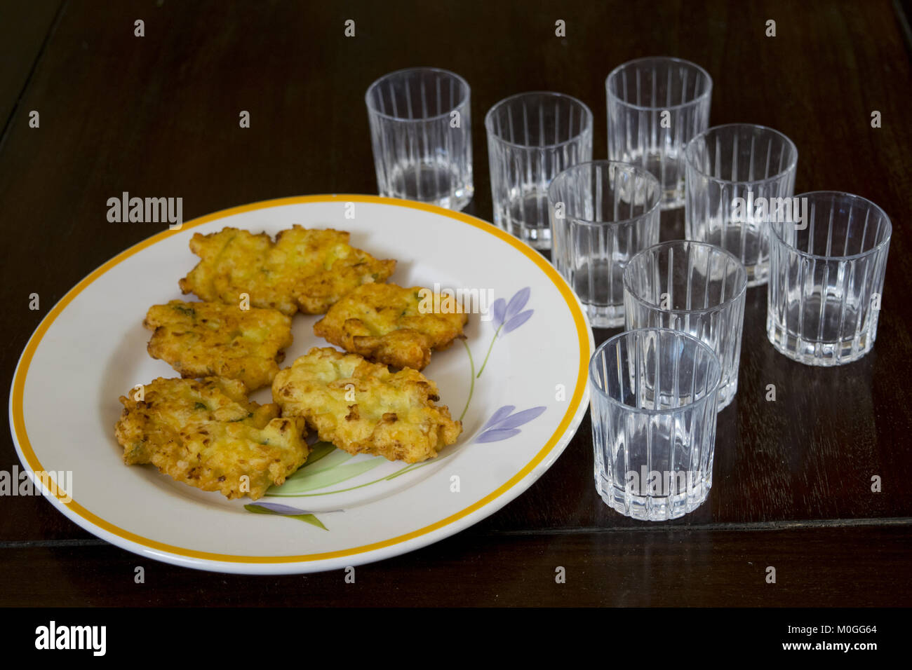 battered and fried potato fritters with some small glasses Stock Photo ...