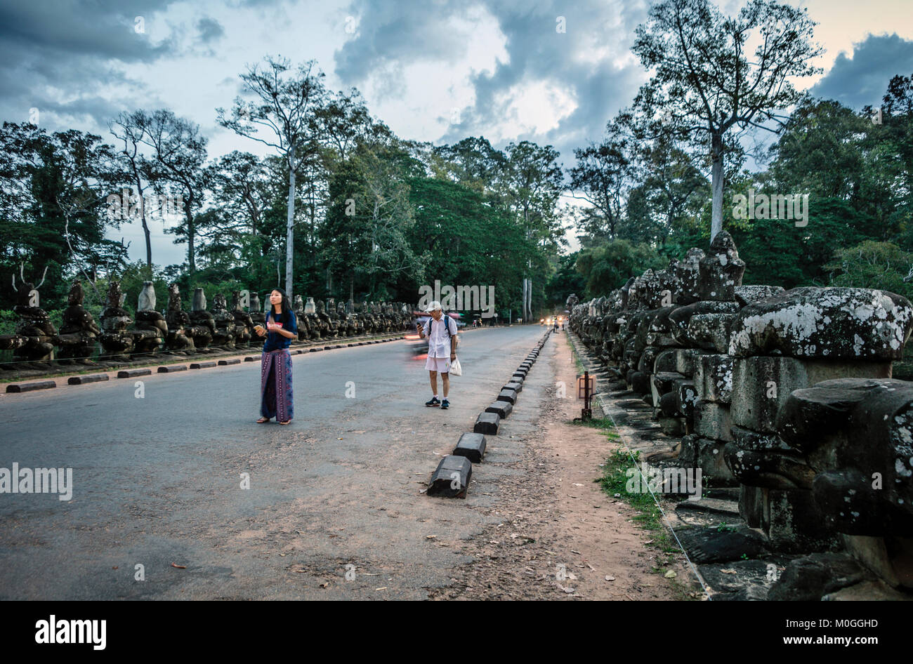 Tourists and traffic on bridge at South gate, Bayon Temple, Angkor Thom ...