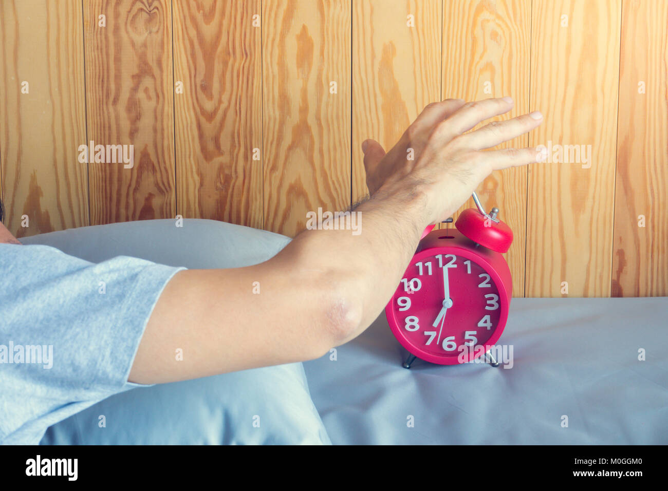 Hand turns off the alarm clock waking up at morning . soft skin tone ...