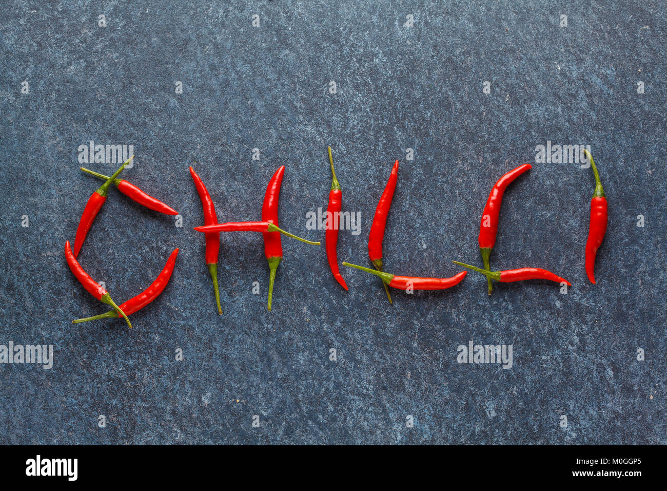 "Chili" from small red chili peppers on a blue background. Vegetable ...
