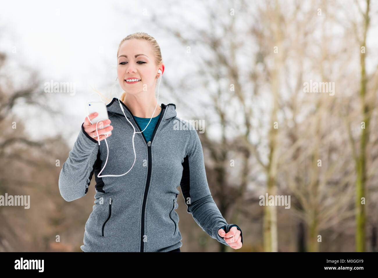 Woman running down a path on winter day in park Stock Photo - Alamy