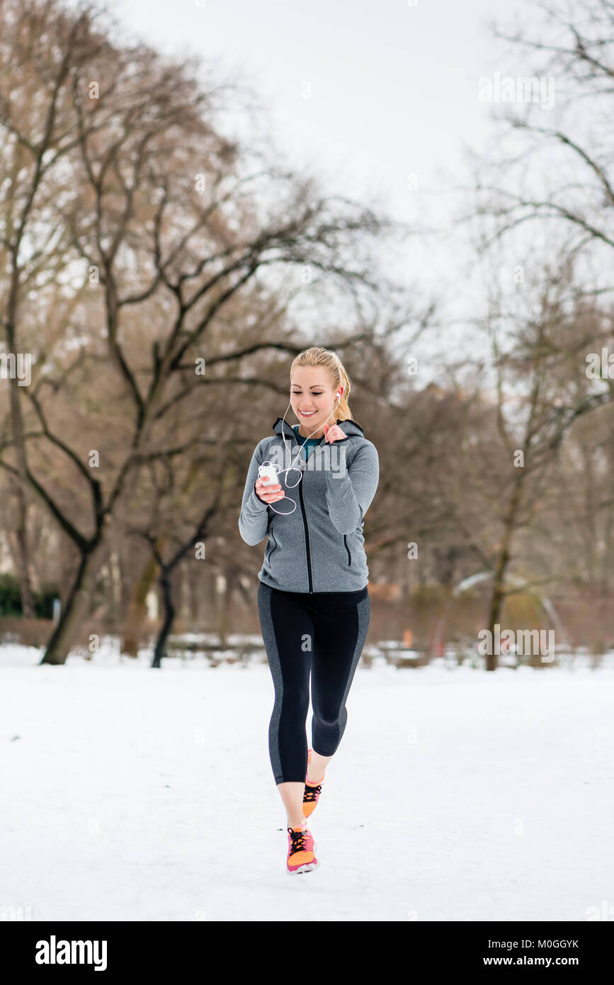 Woman running down a path on winter day in park Stock Photo - Alamy