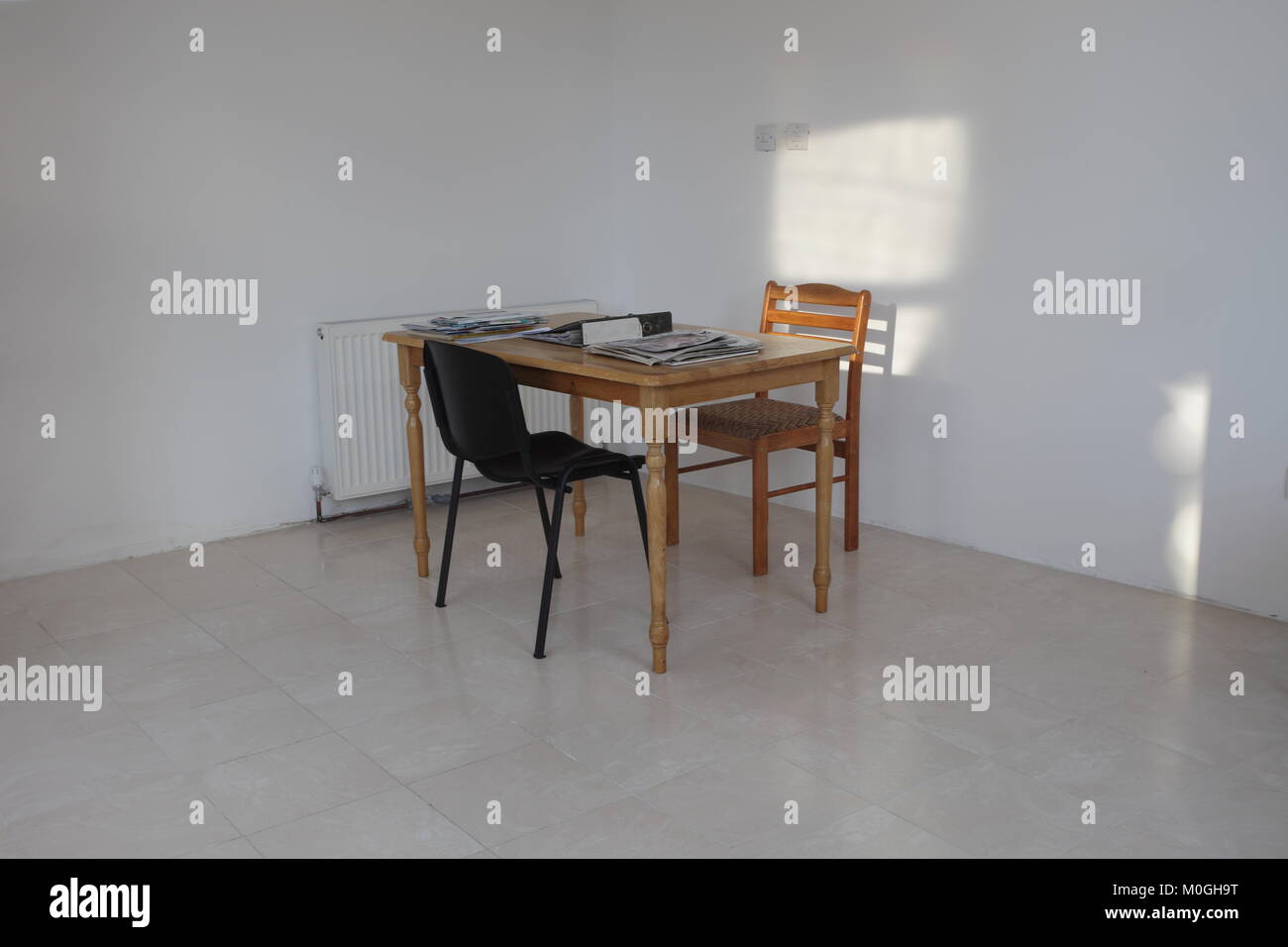 A table and two chairs in an otherwise empty room Stock Photo - Alamy