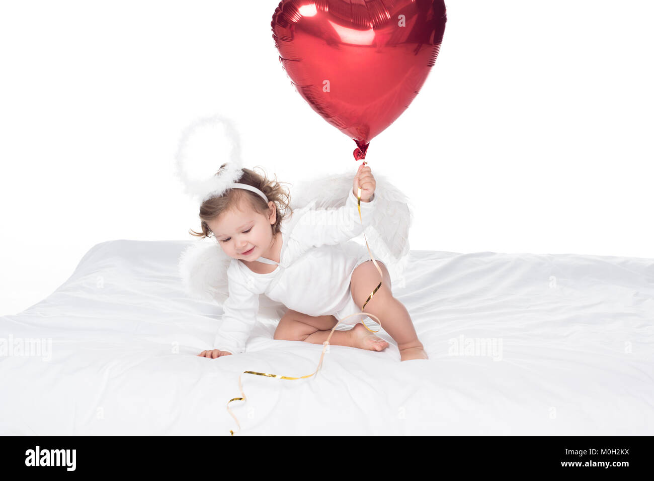 little angel with wings and nimbus holding heart balloon, isolated on ...