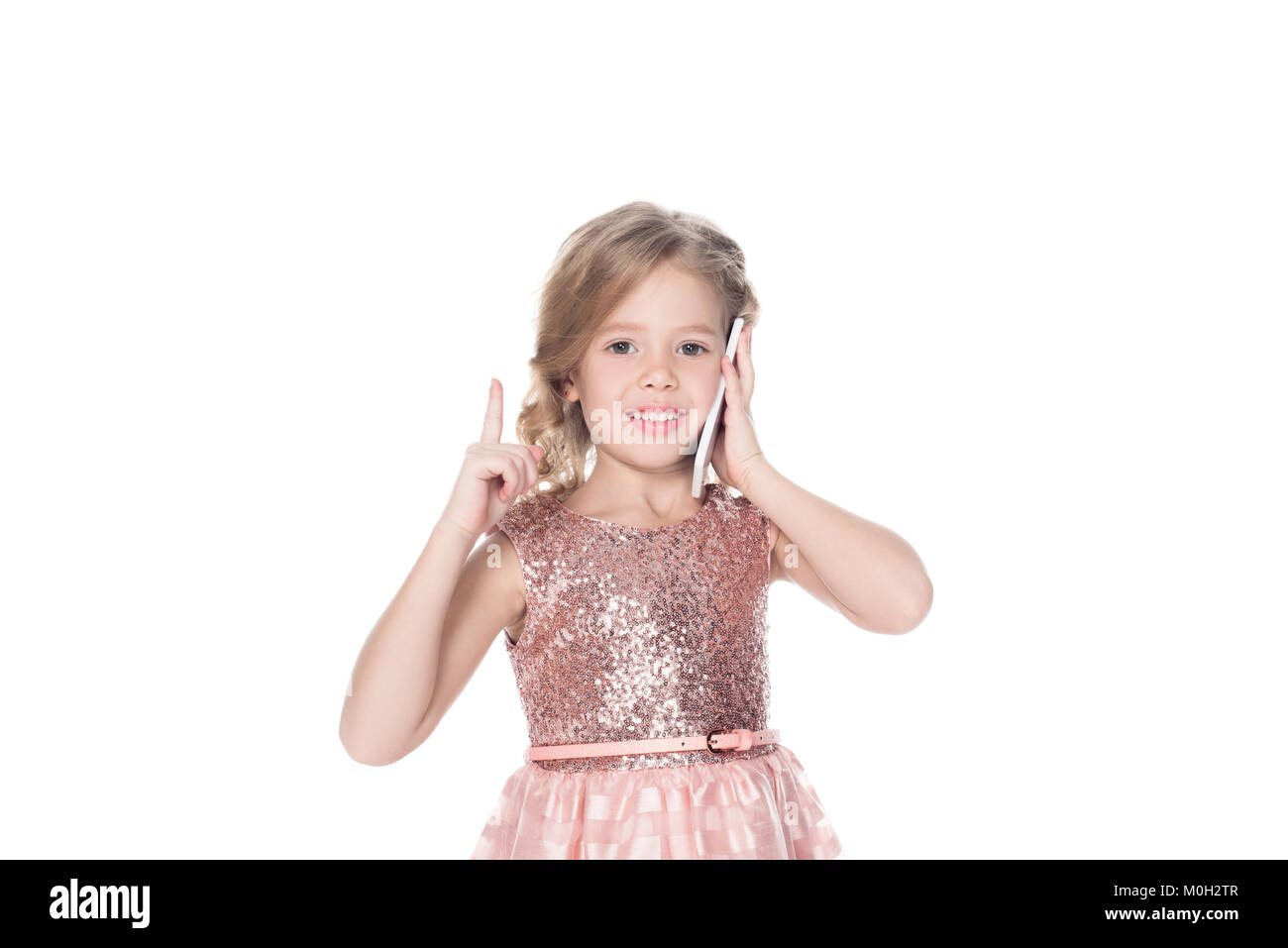 cheerful child pointing up while talking on smartphone, isolated on ...