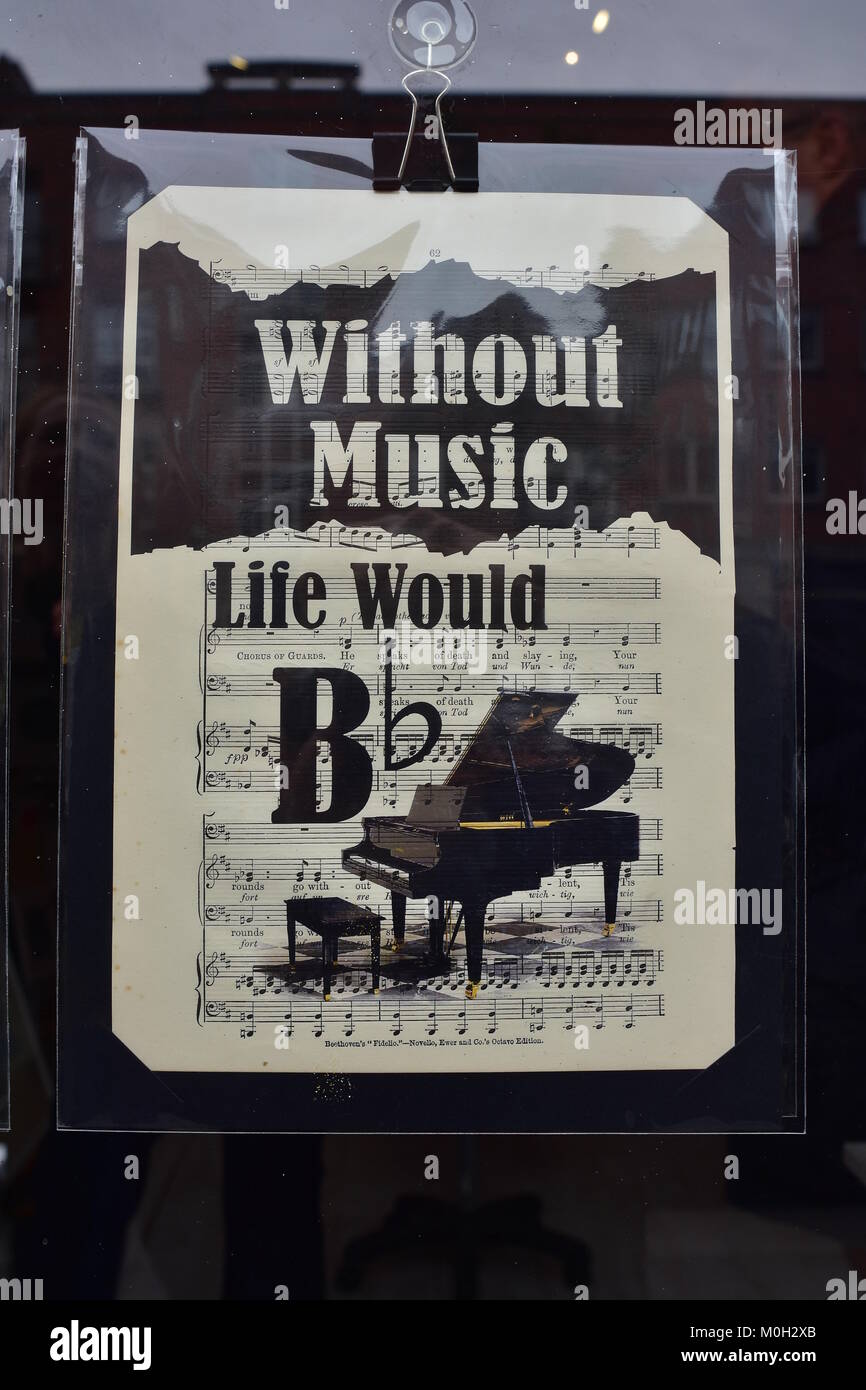 Sheet of paper with musical pun on life without music behind reflecting ...