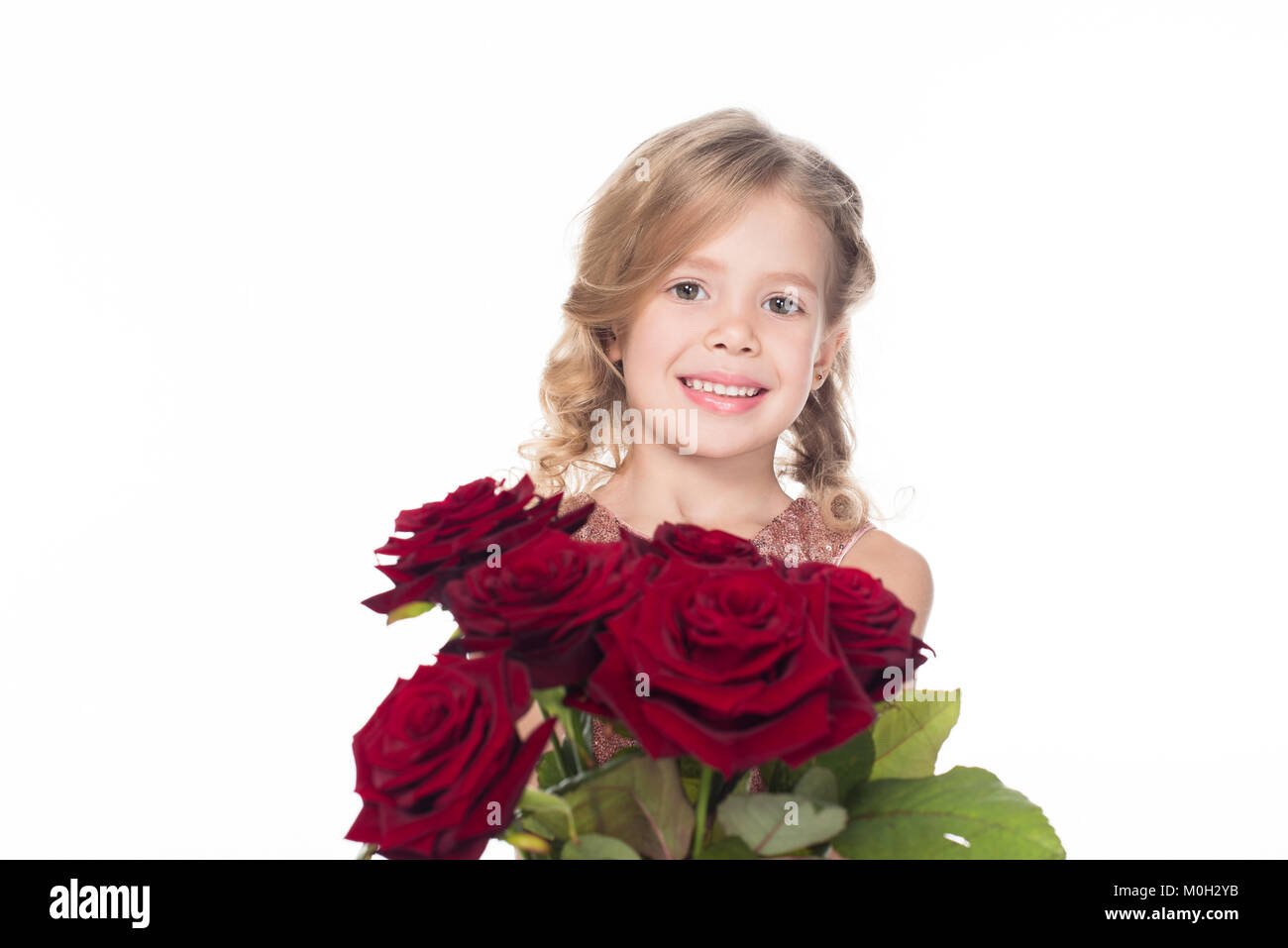smiling kid in dress holding bouquet of red roses, isolated on white ...