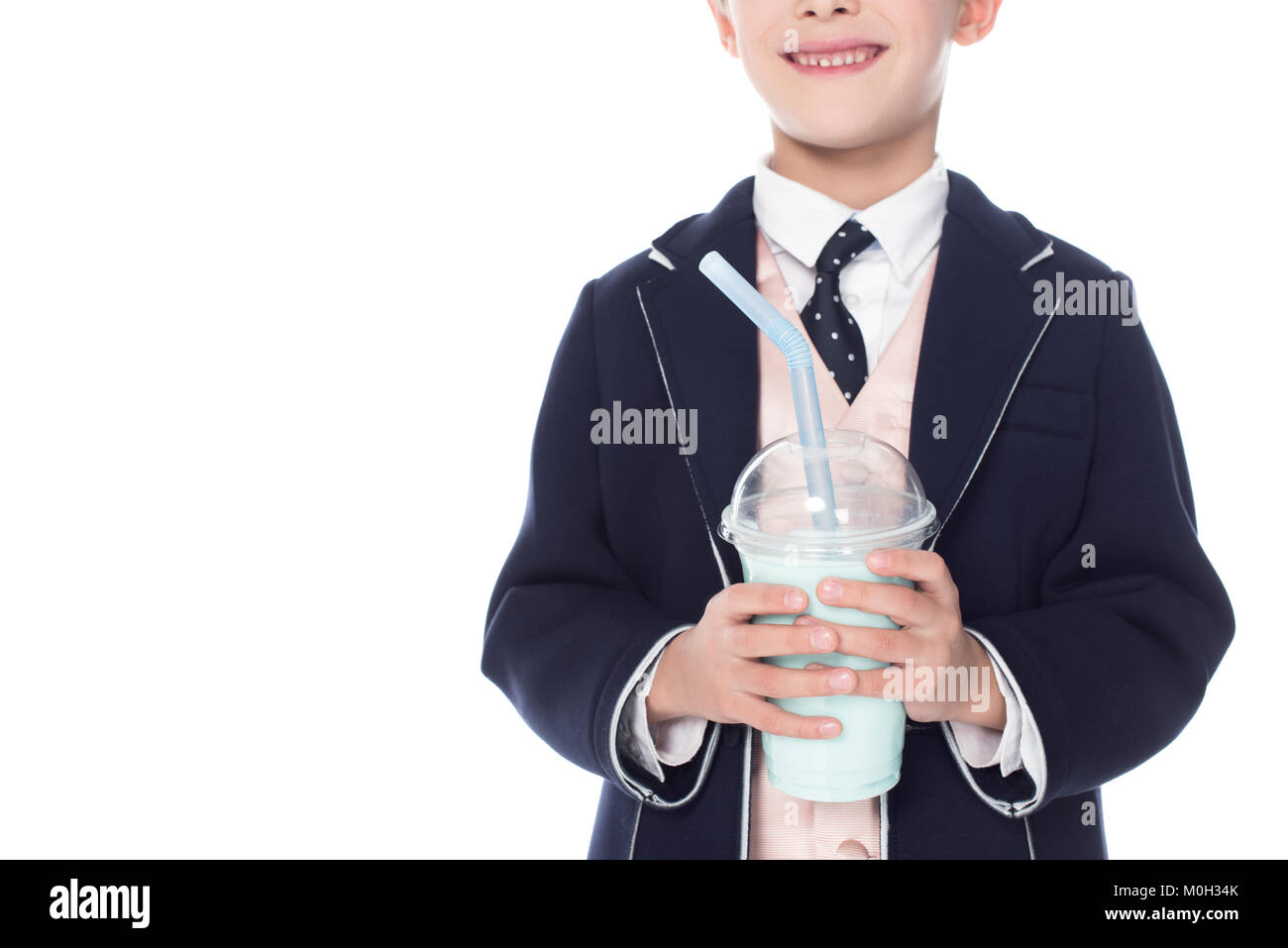 cropped shot of smiling little boy in suit holding milkshake in plastic ...