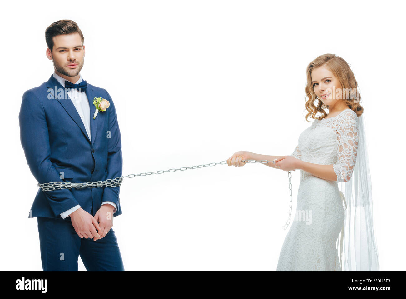 young bride holding groom on chain isolated on white Stock Photo - Alamy