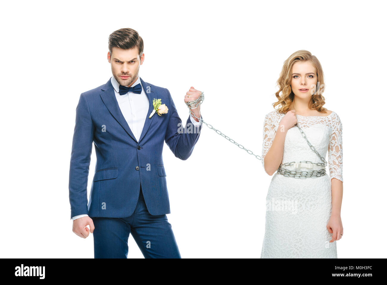 groom holding shocked young bride on chain isolated on white Stock ...