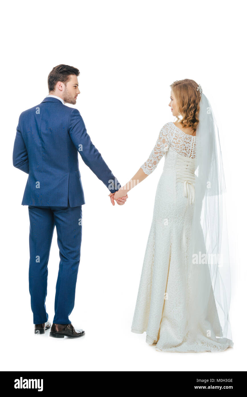 back view of beautiful wedding couple holding hands isolated on white ...
