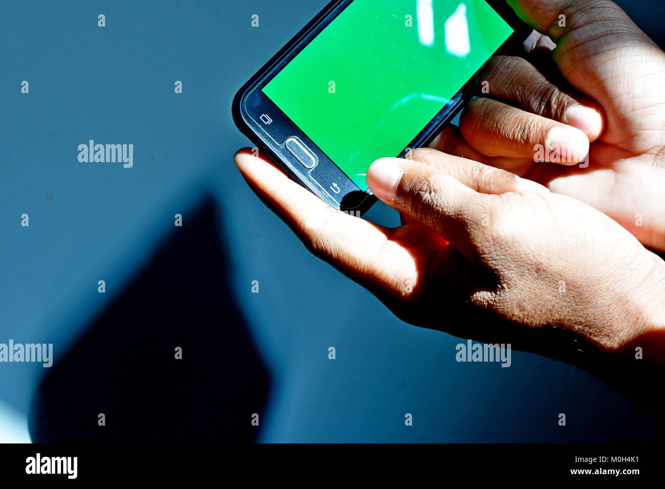 Green screen ready android and man viewing against striped window of ...