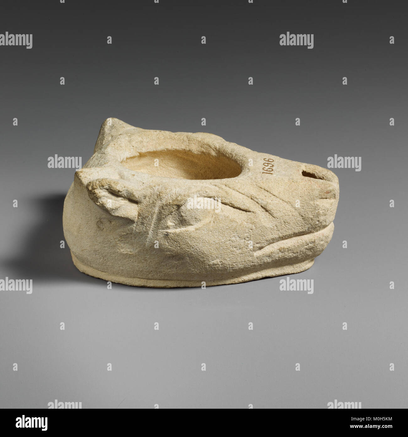 This limestone lamp, shaped like a bull's head, showcases ancient ...