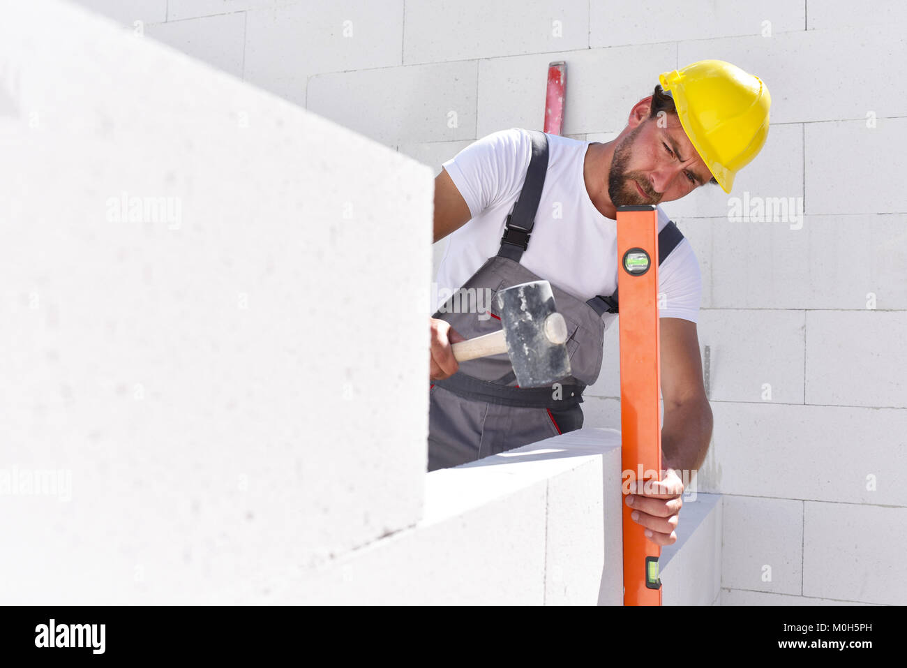 craftsmen at home construction - bricklayers working in work clothes ...