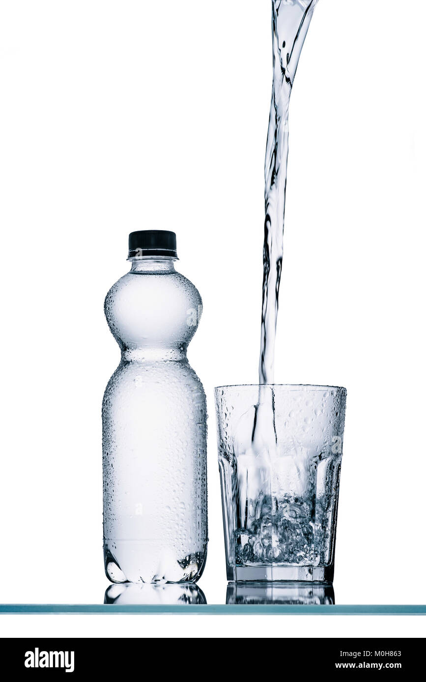 plastic bottle and water pouring into glass isolated on white Stock ...