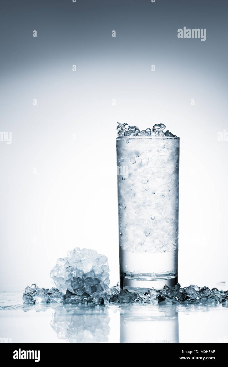 glass of cold water with ice on reflective surface on white Stock Photo ...