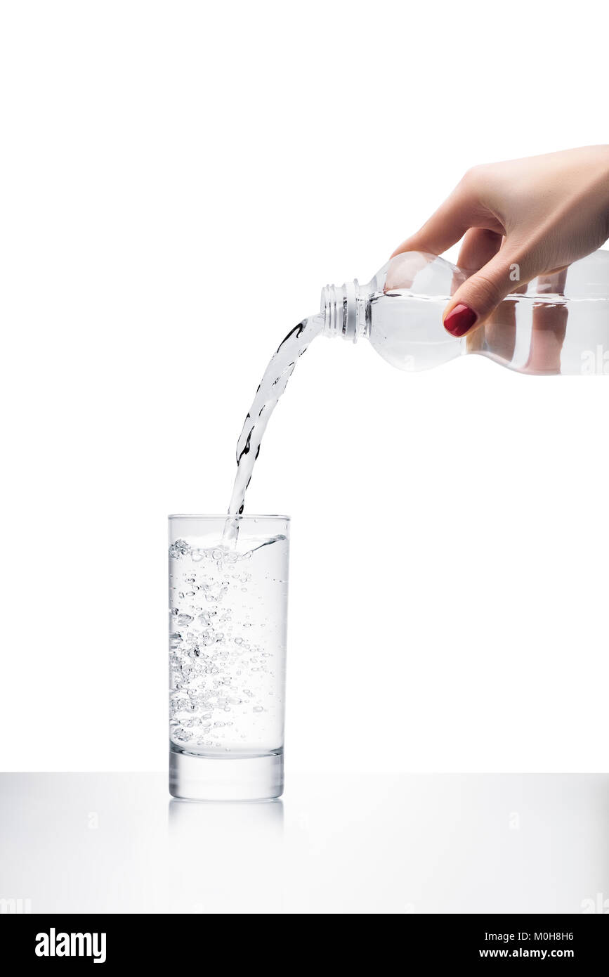 cropped shot of woman pouring clean water into glass from plastic ...
