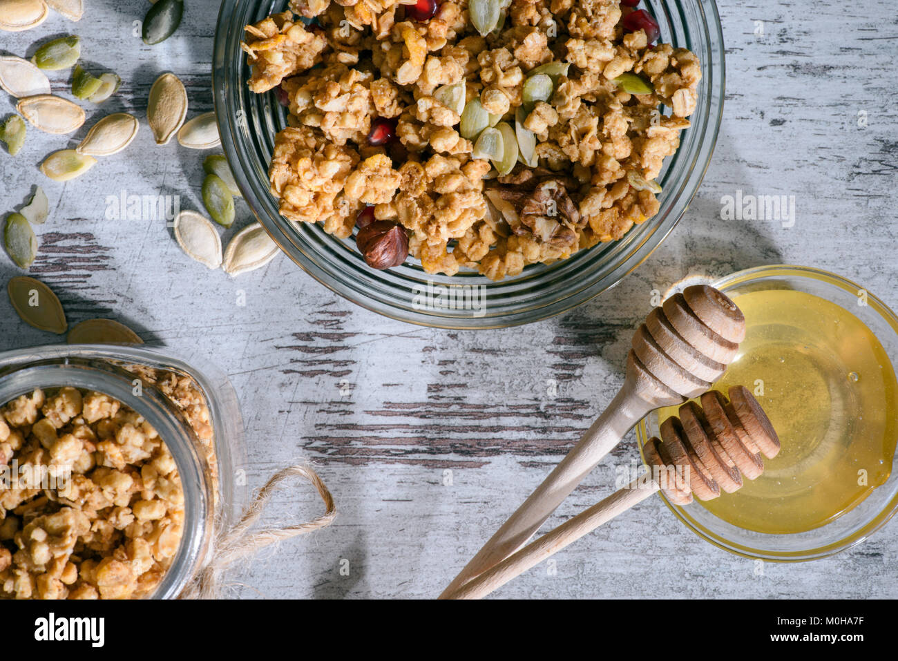 top view of granola and honey with sticks on wooden surface Stock Photo ...
