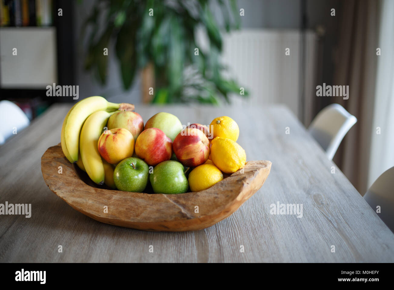 Wooden fruit basket on table in living room Stock Photo - Alamy