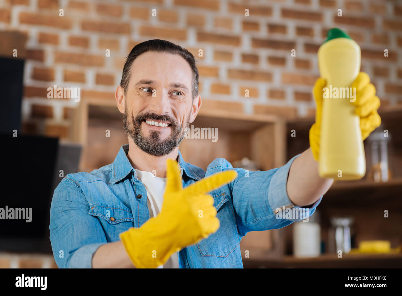 Jolly male cleaner satisfied with cleanser power Stock Photo - Alamy