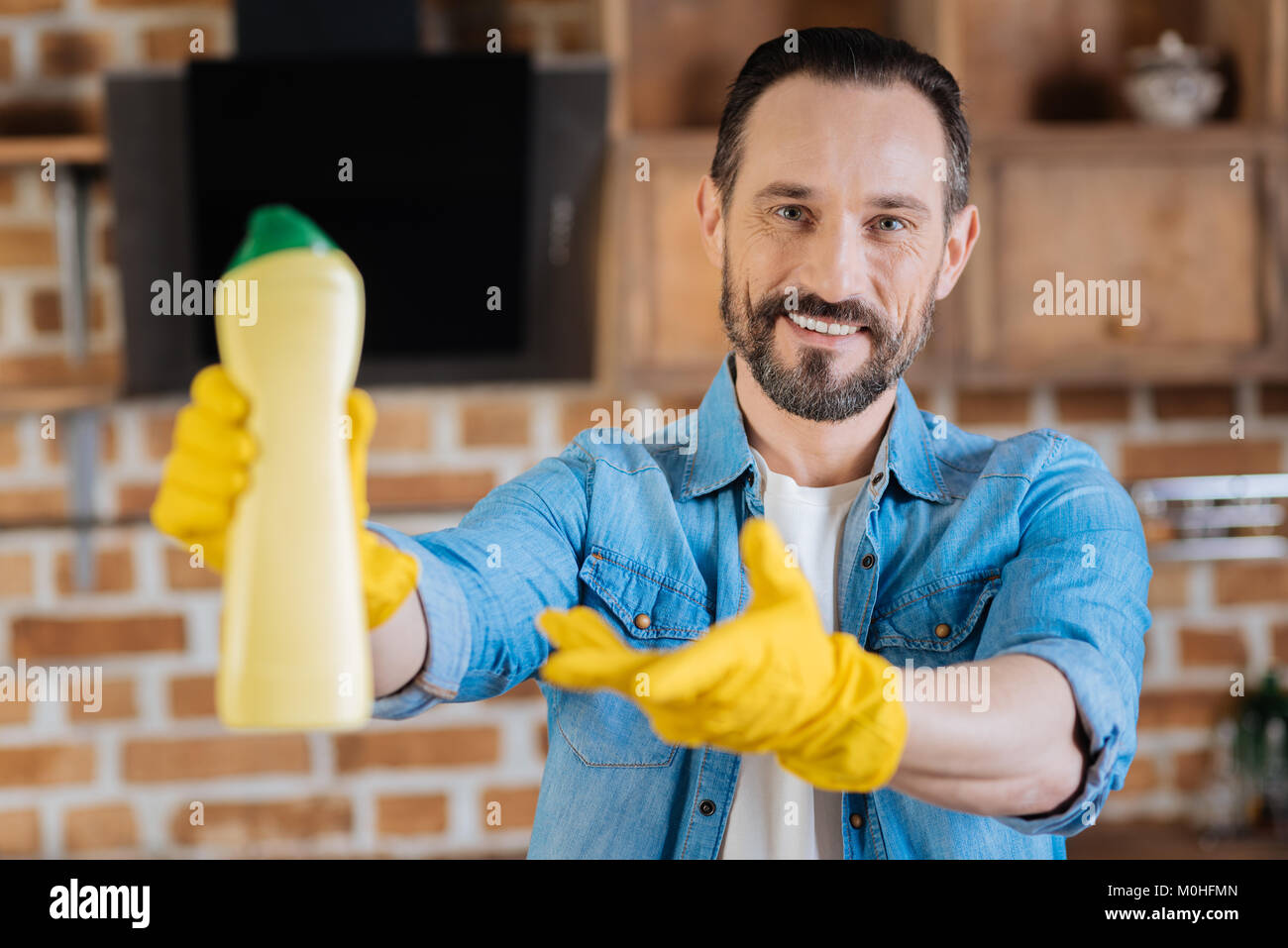 Optimistic male cleaner sharing his cleanser Stock Photo - Alamy