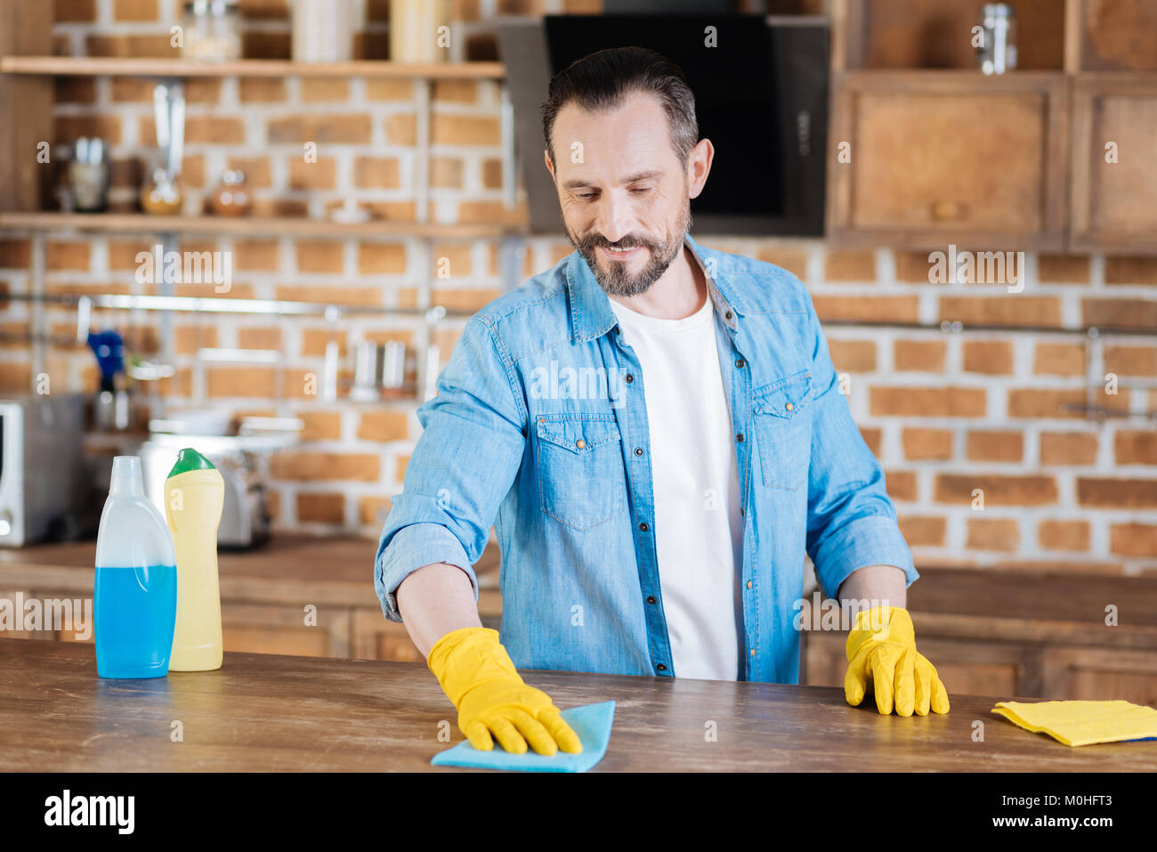 Happy male cleaner wiping surface Stock Photo - Alamy