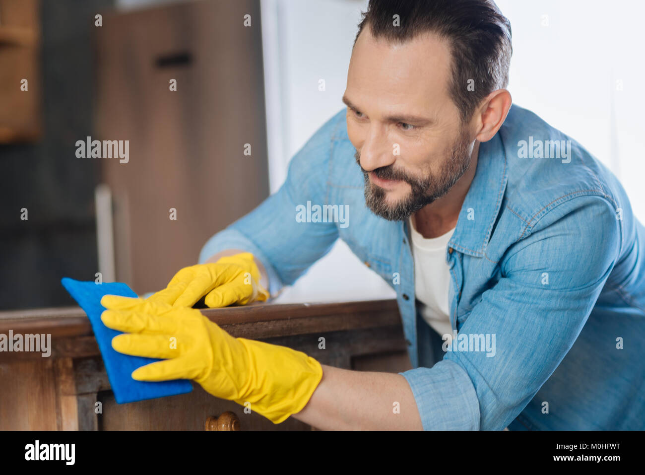 Pleased male cleaner working with cleaning cloth Stock Photo - Alamy