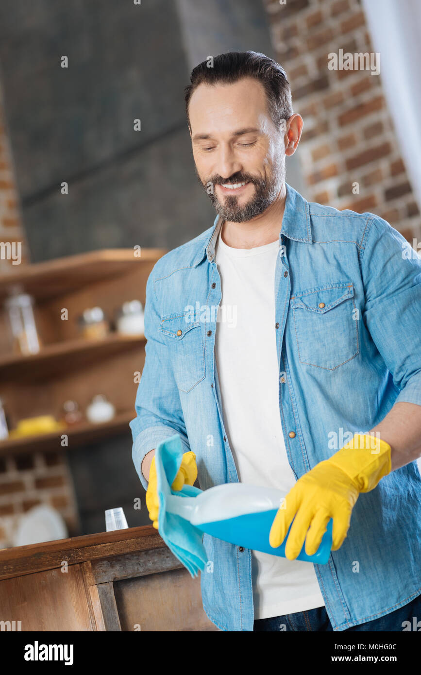 Musing male cleaner utilizing cleanser Stock Photo - Alamy