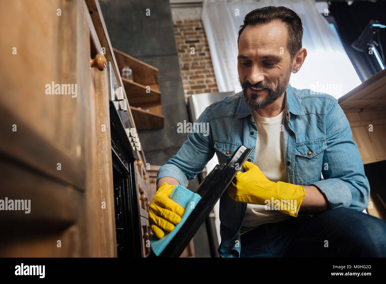 Gay male cleaner brightening surface Stock Photo - Alamy