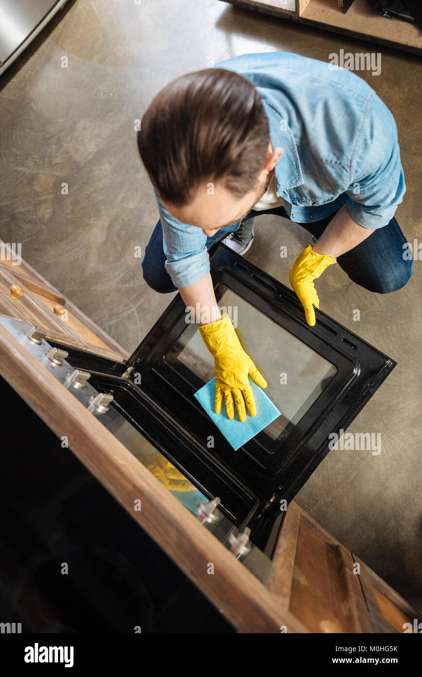 Busy male cleaner cleaning from grease Stock Photo - Alamy