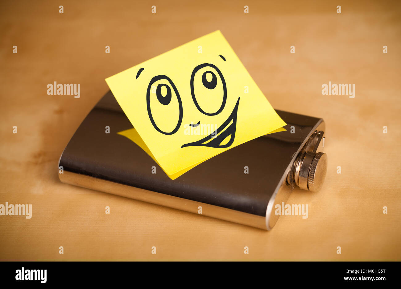Drawn smiley face on a post-it note sticked on a hip flask Stock Photo ...