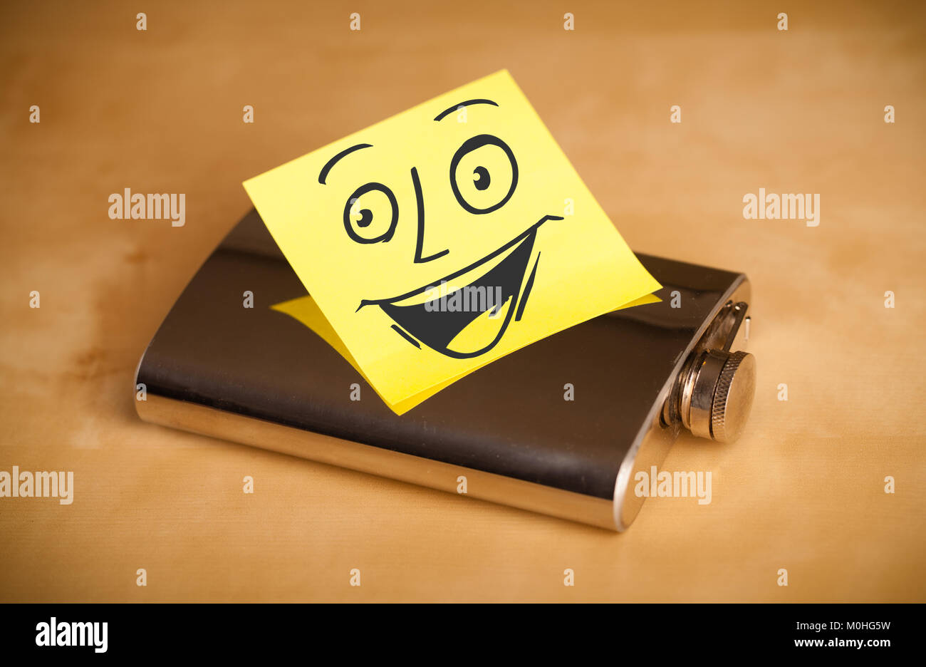 Drawn smiley face on a post-it note sticked on a hip flask Stock Photo ...