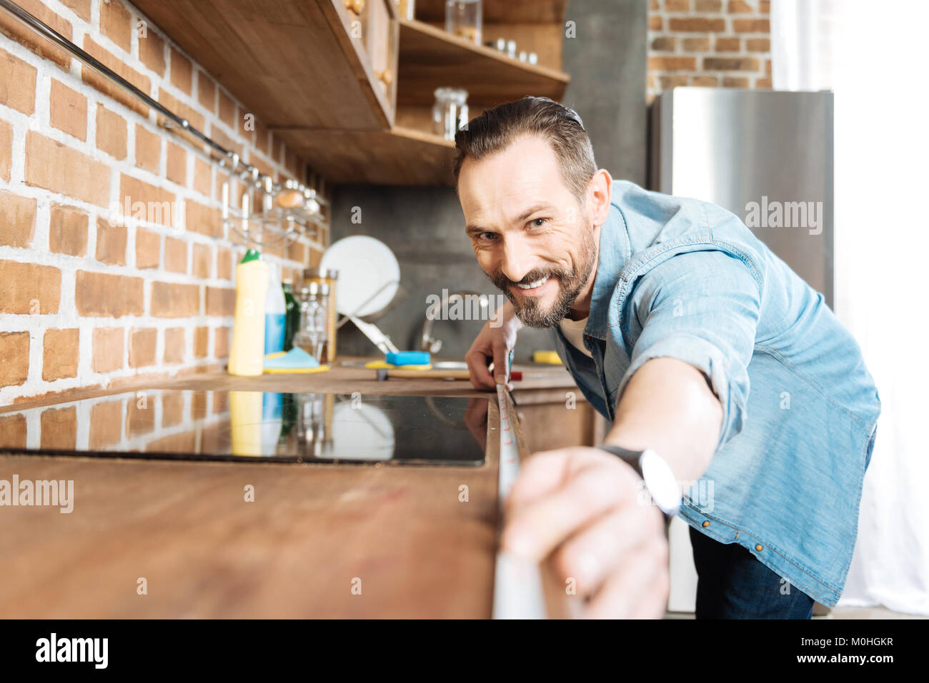 Positive happy man calculating measurement Stock Photo - Alamy