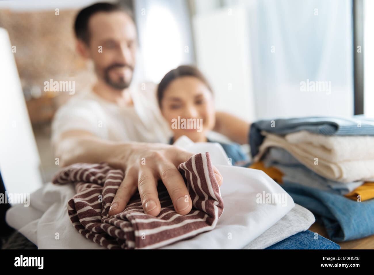 Young jolly couple busy with laundry Stock Photo - Alamy