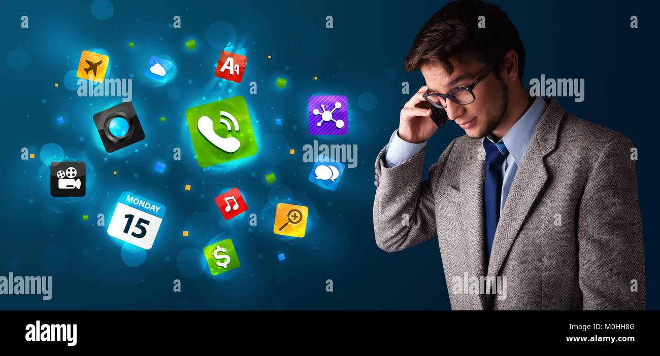 Handsome young man calling by phone with various icons Stock Photo - Alamy