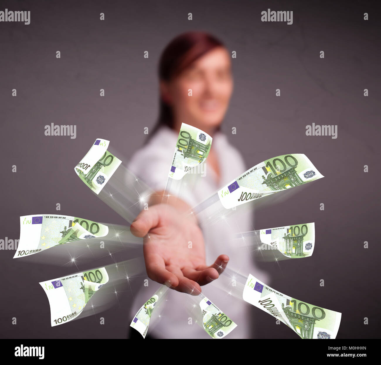 Pretty young woman standing and throwing money Stock Photo - Alamy