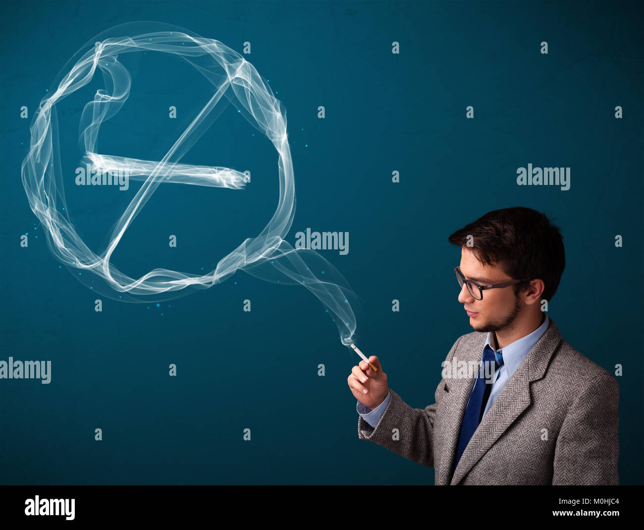 Handsome young man smoking unhealthy cigarette with no smoking sign ...