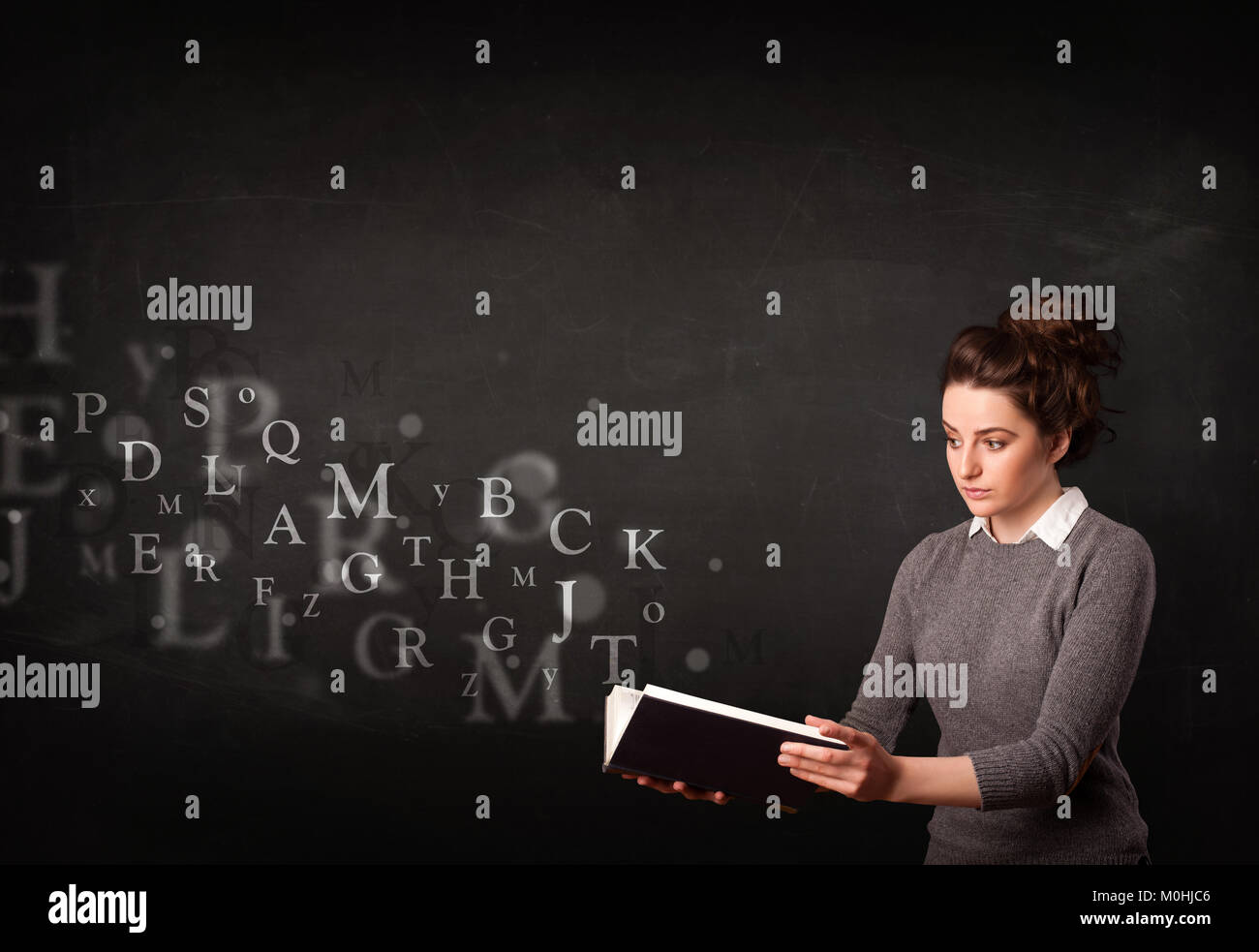 Young lady reading a book with alphabet letters coming out of the book ...