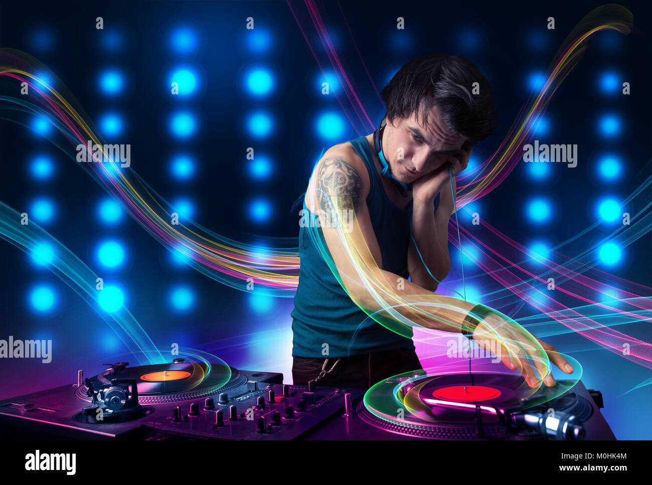 Attractive young Dj mixing records with colorful lights Stock Photo - Alamy