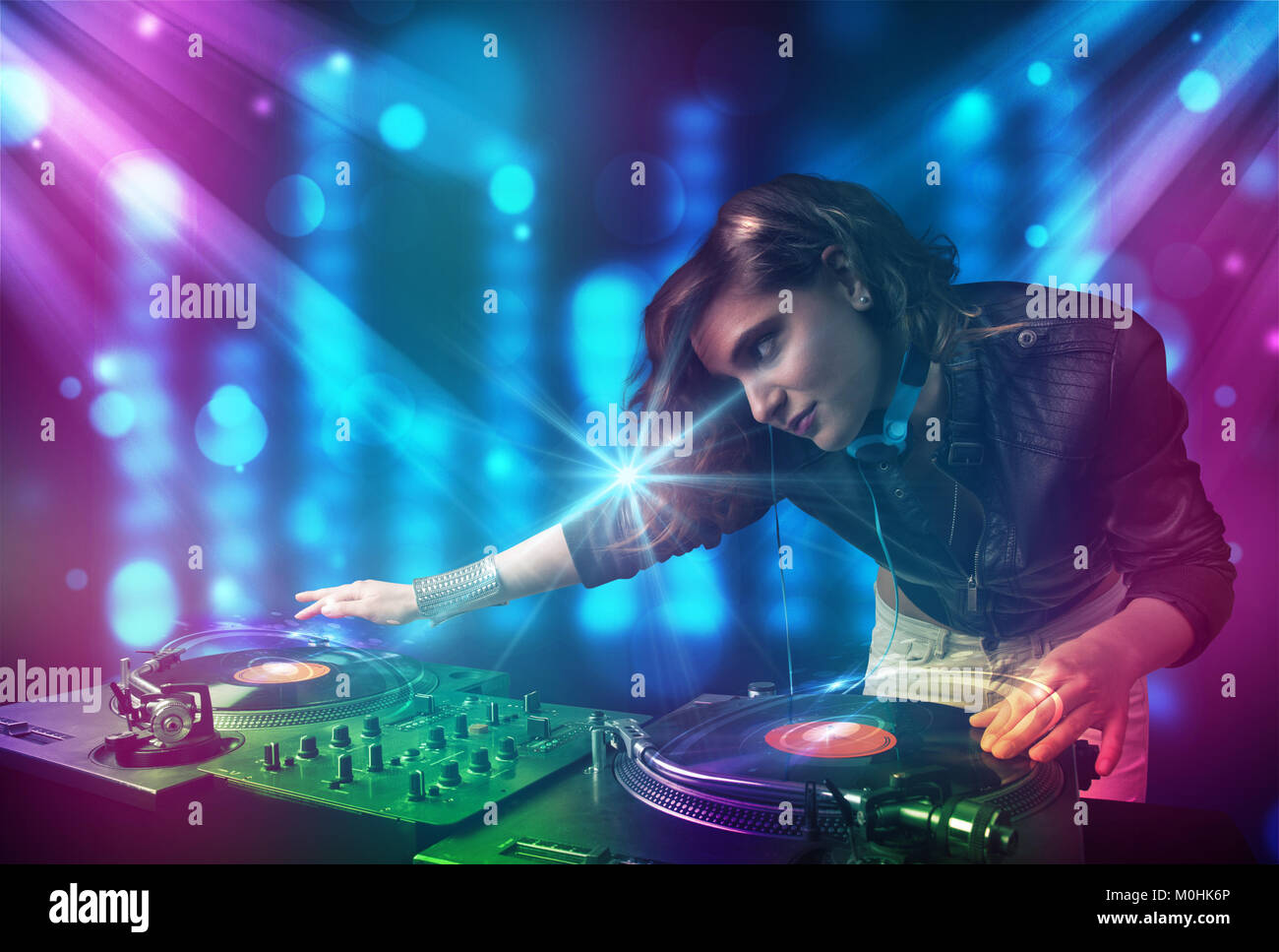 Pretty Dj mixing music in a club with blue and purple lights Stock ...