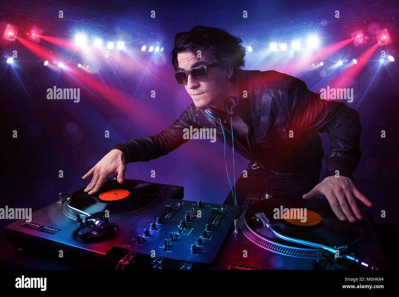 Handsome teenager dj mixing records in front of a crowd on stage Stock ...